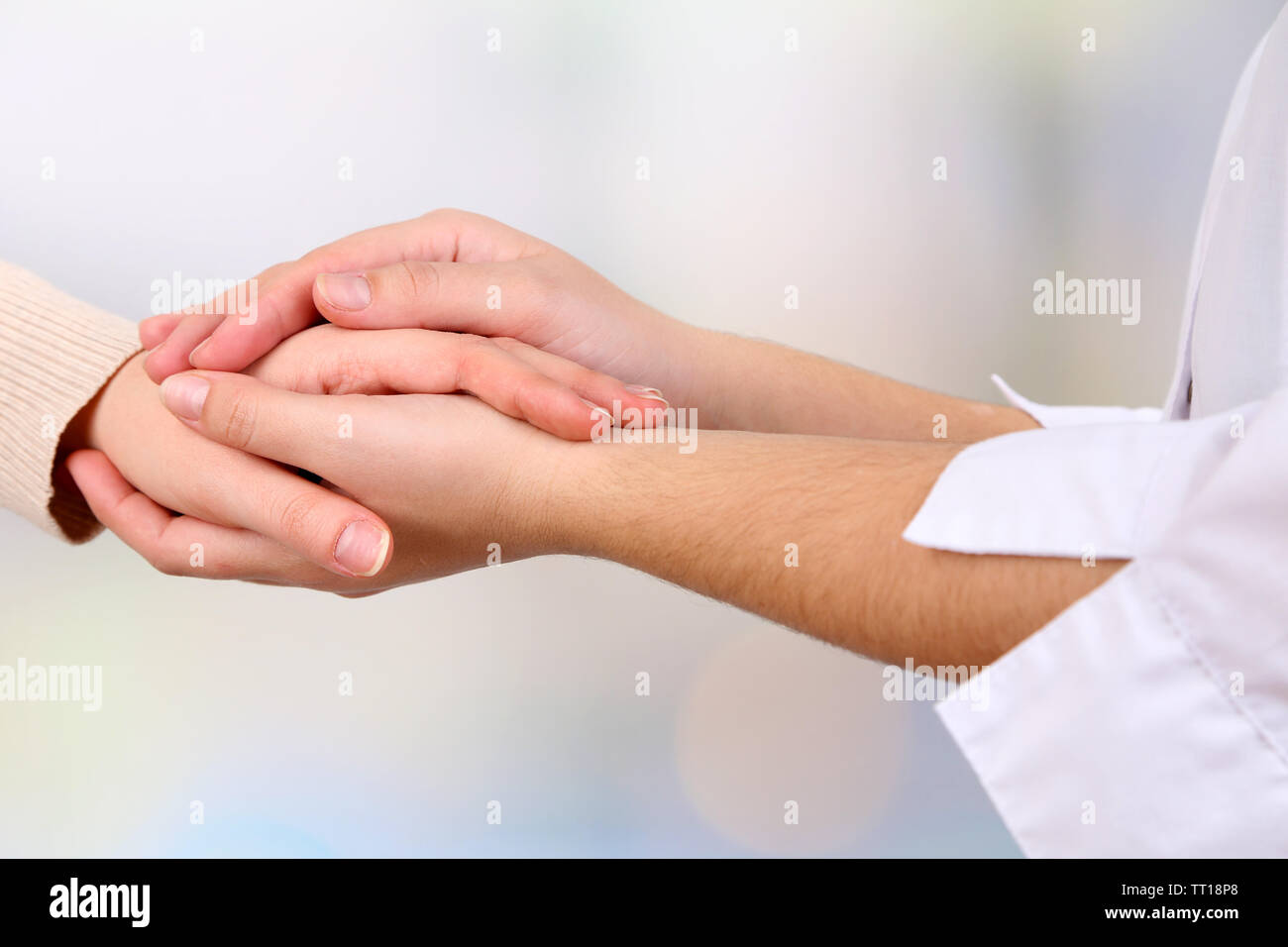 Medical doctor holding hand of patient, on light background Stock Photo ...