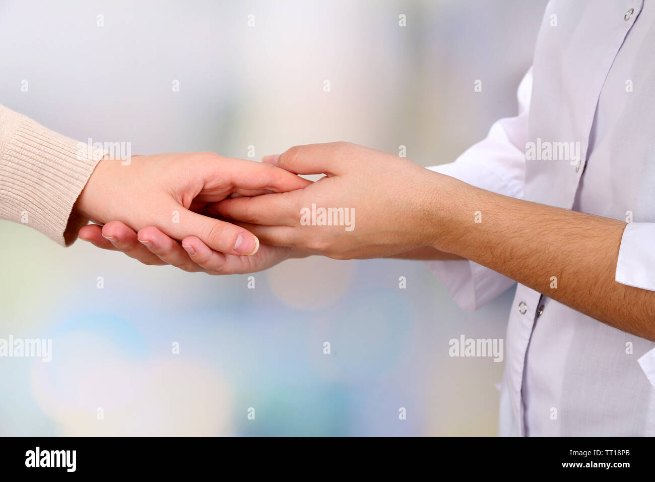 Medical doctor holding hand of patient, on light background Stock Photo ...