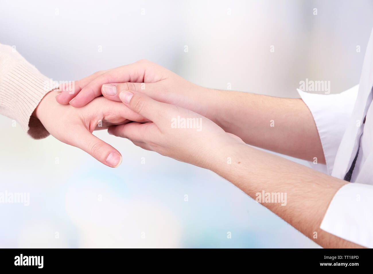 Medical doctor holding hand of patient, on light background Stock Photo ...