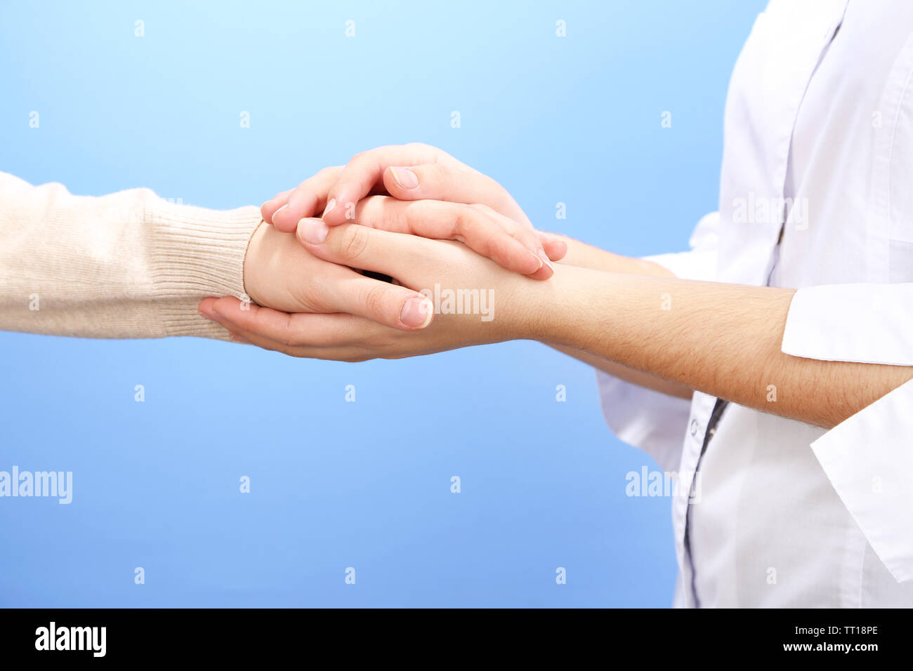 Medical doctor holding hand of patient, on light background Stock Photo ...