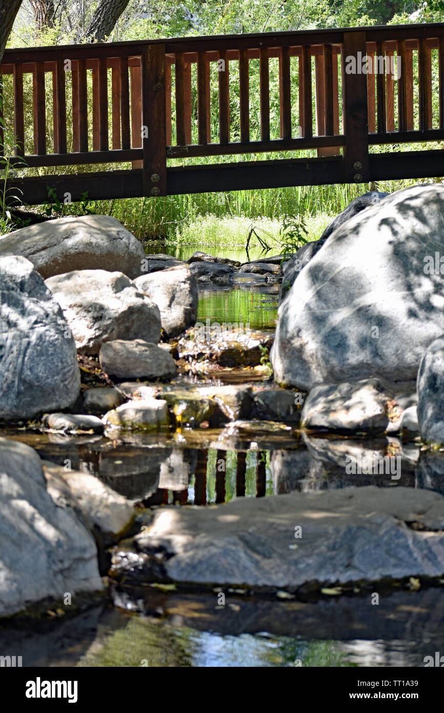 Bridge over stream in Mountains Stock Photo - Alamy
