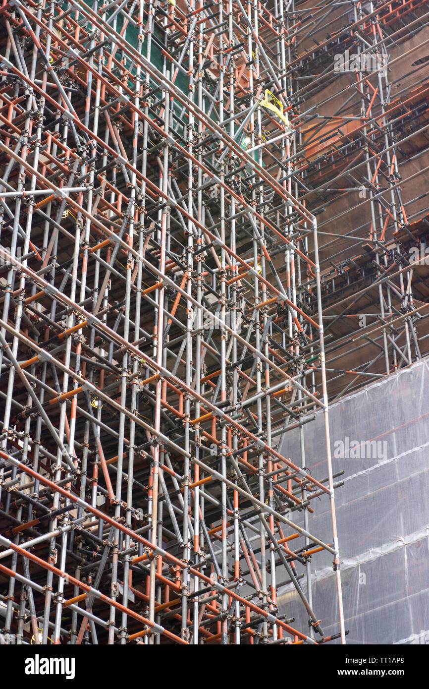 building under construction in city with scaffolding and netting Stock ...
