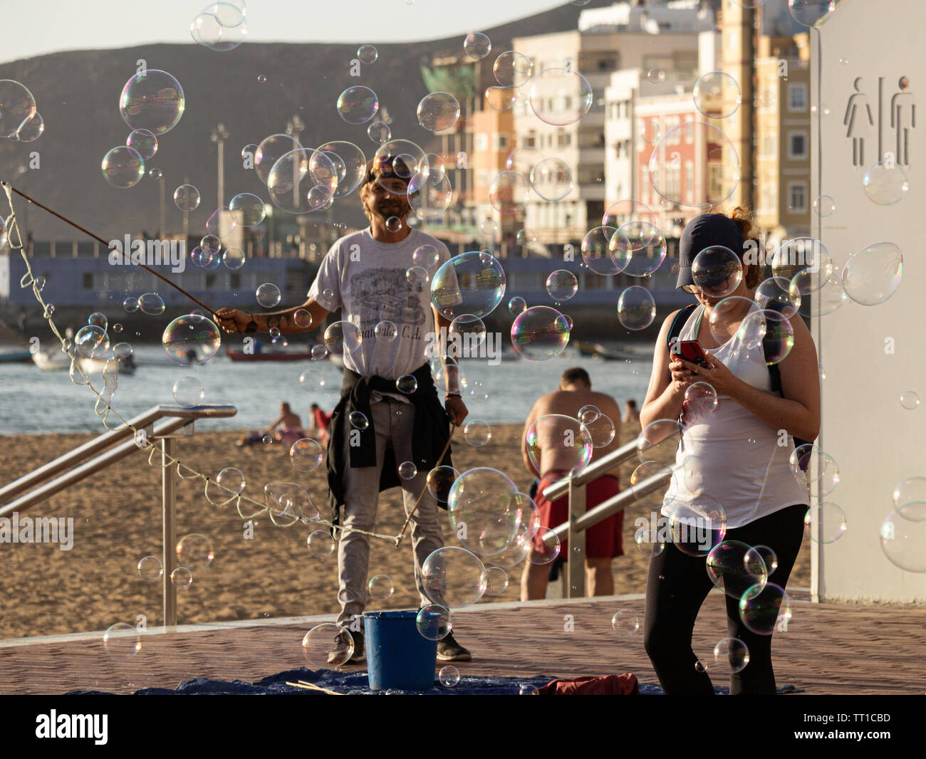 Busker making bubbles on beach in Spain Stock Photo - Alamy