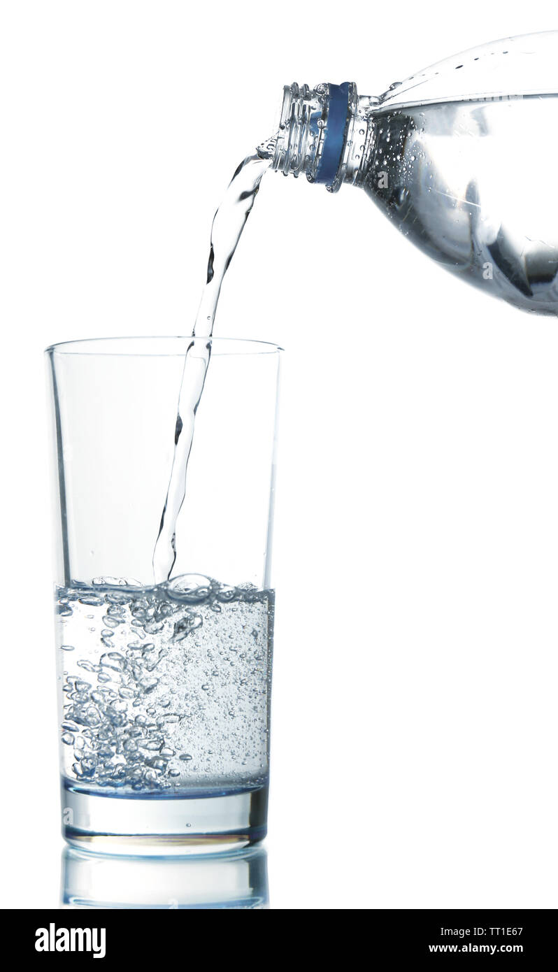 Pour water from bottle into glass, isolated on white Stock Photo - Alamy