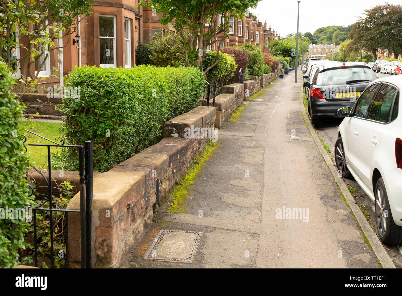 Pavement, low stone wall and front gardens, in the Victorian suburb of ...