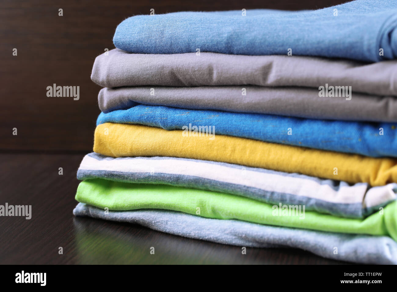 Stack of colorful clothes, on dark background Stock Photo - Alamy