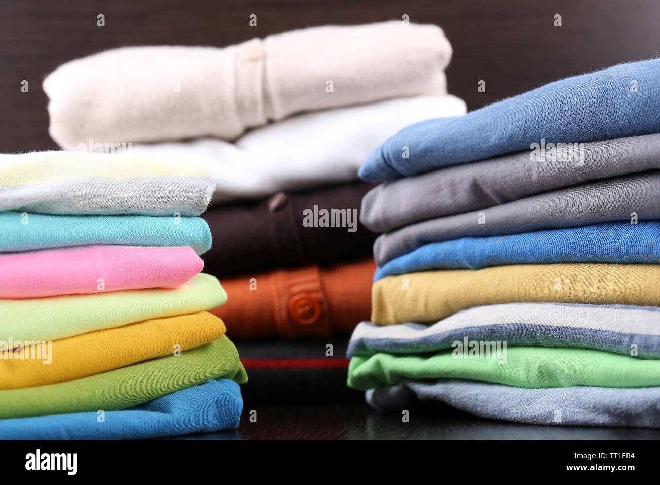 Stack of colorful clothes, on dark background Stock Photo - Alamy