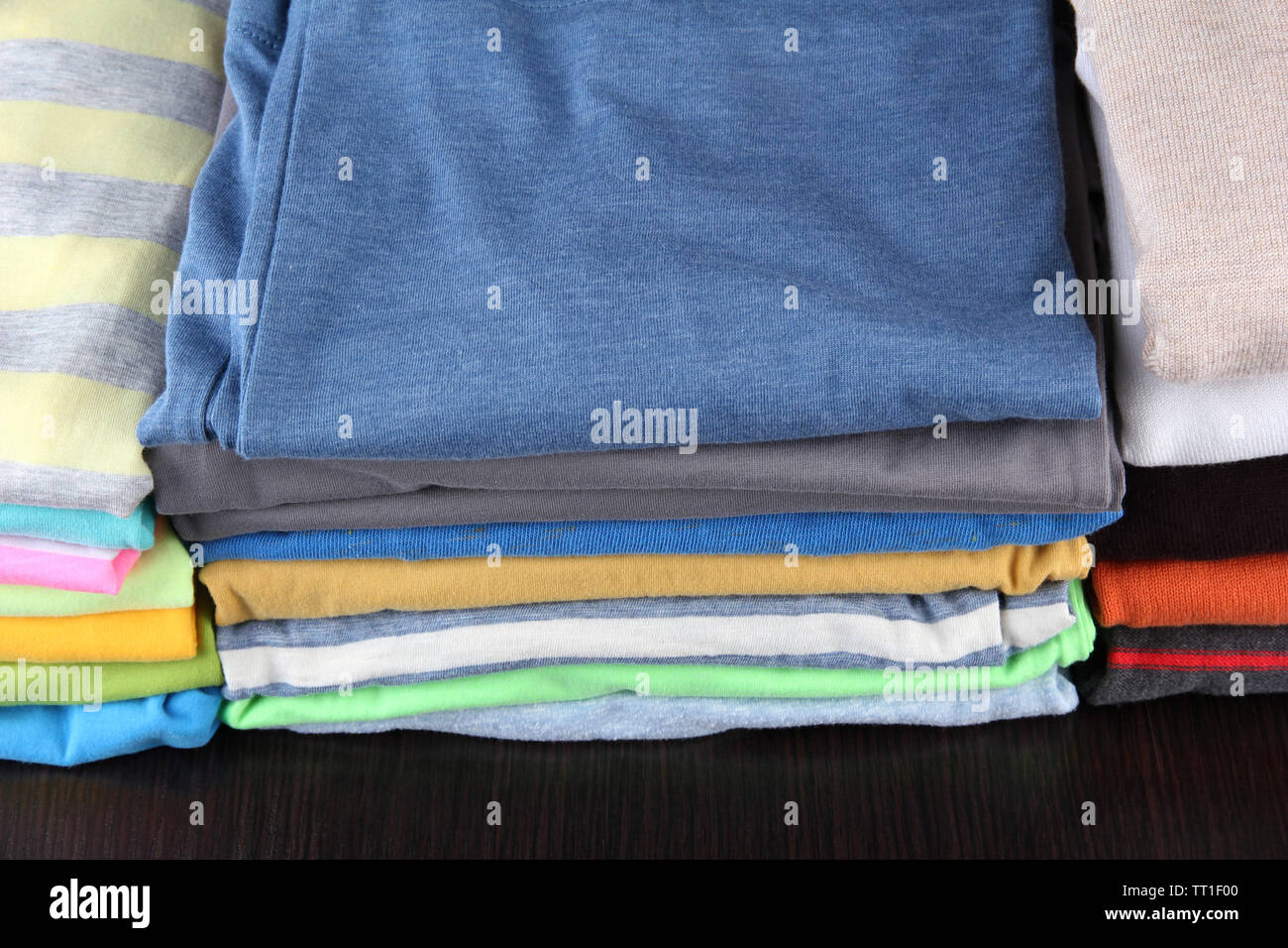 Stack of colorful clothes, on dark background Stock Photo - Alamy