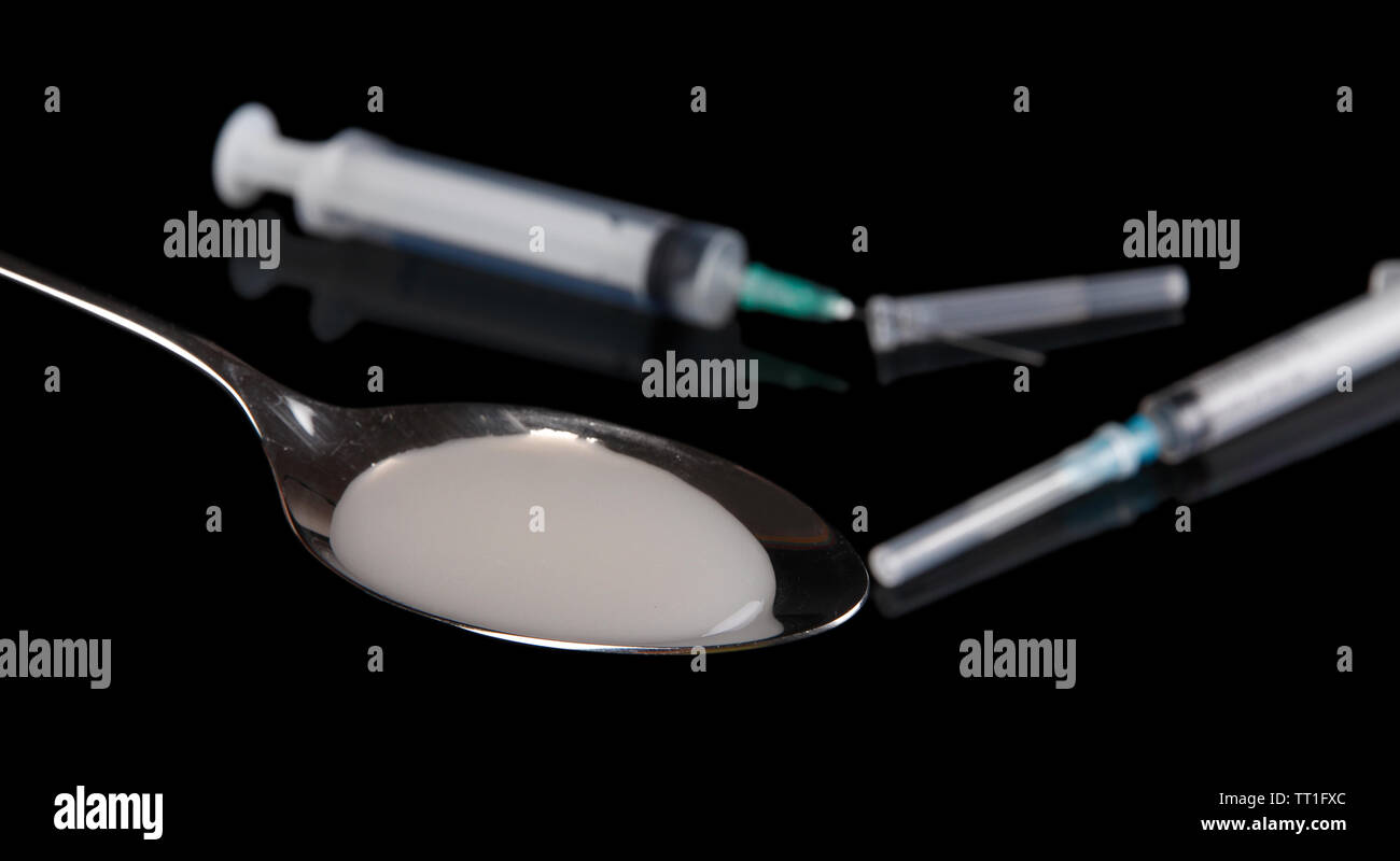 Heroin in spoon on black background Stock Photo - Alamy