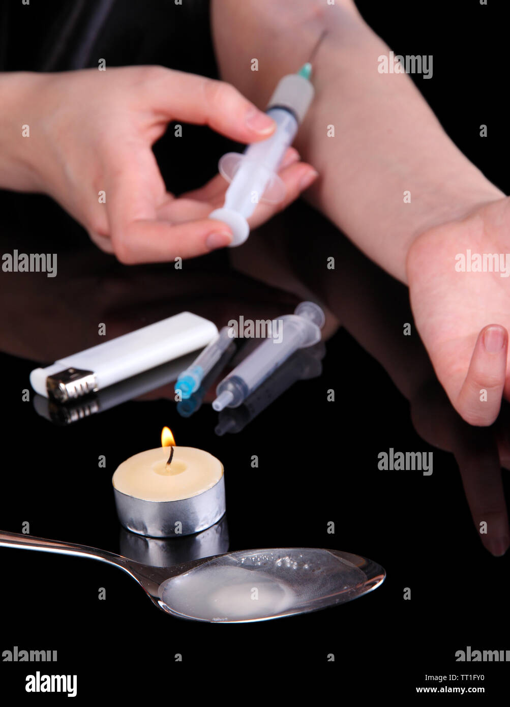Drug addict with syringe in action on black background Stock Photo - Alamy