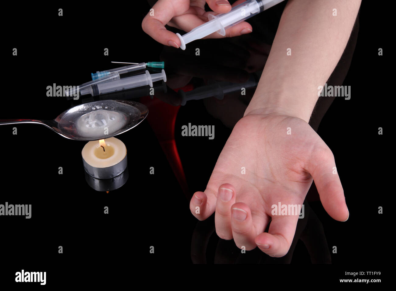 Drug addict with syringe in action on black background Stock Photo - Alamy