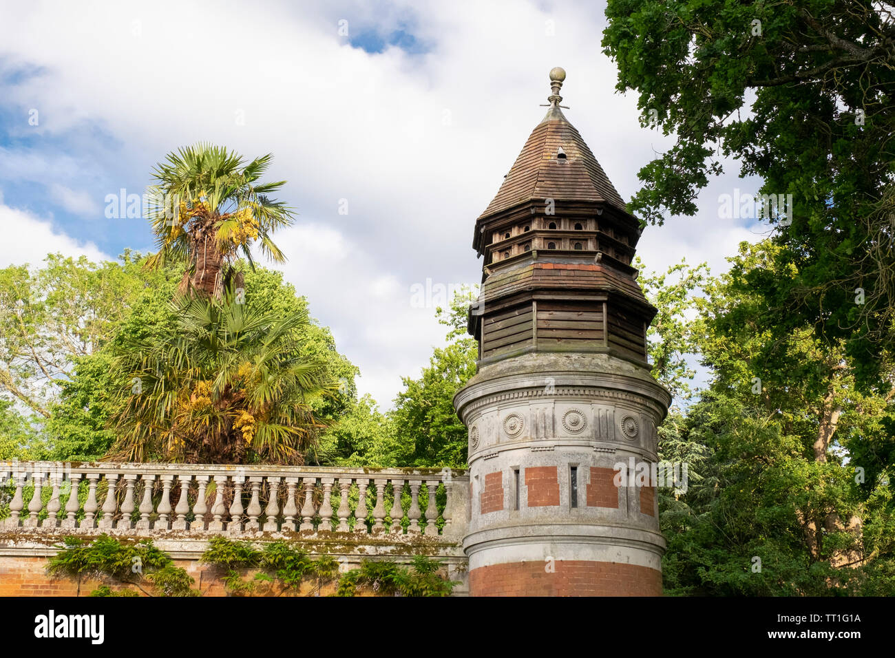 Octagonal old wooden Dovecote with tiled roof on top of round tower in ...