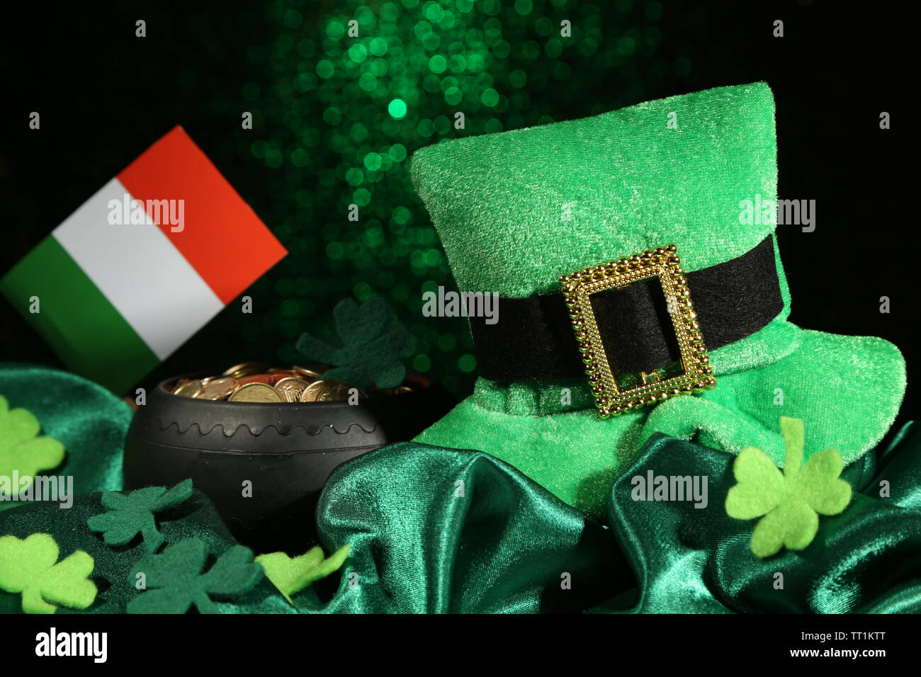 Saint Patrick day hat, pot of gold coins and Irish flag on green shiny ...