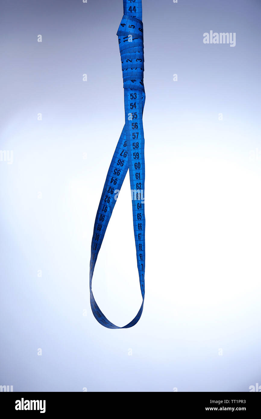 Tape measure noose on blue background - diet concept Stock Photo - Alamy