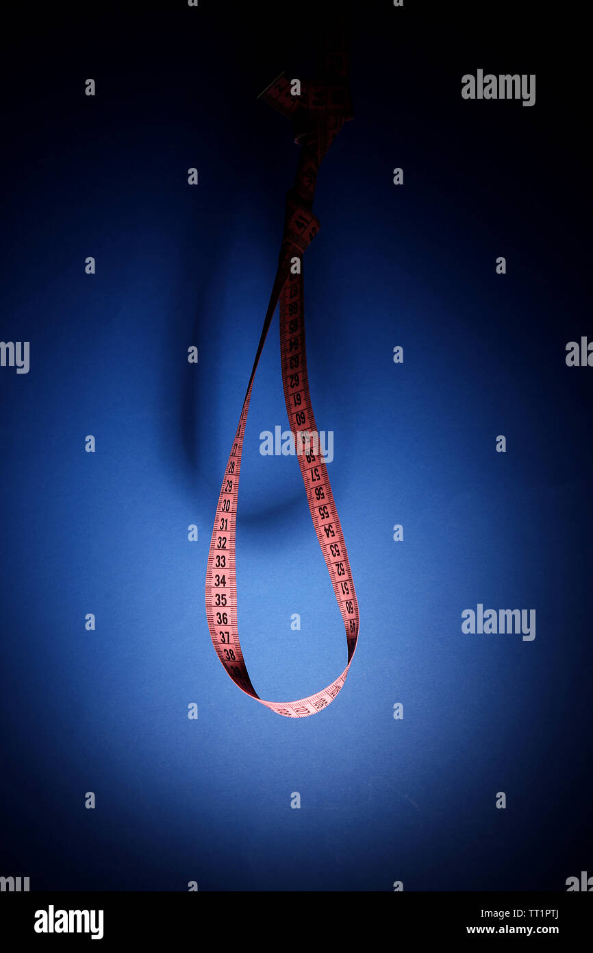 Tape measure noose on blue background - diet concept Stock Photo - Alamy