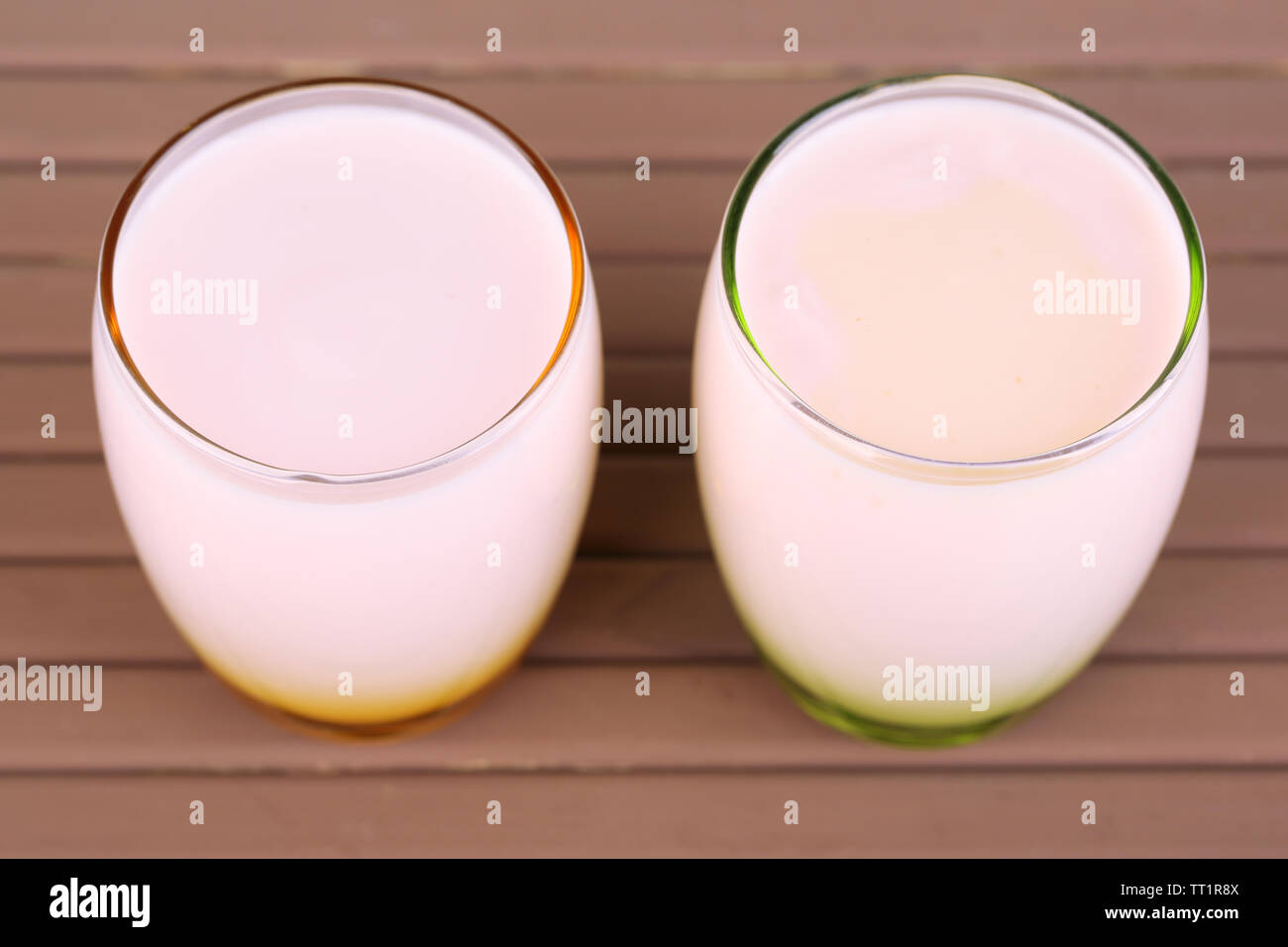 Delicious yogurt with fruits tastes in glasses on color wooden table ...