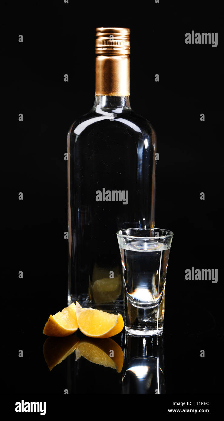 Bottle of vodka and lemon slice isolated on black Stock Photo - Alamy