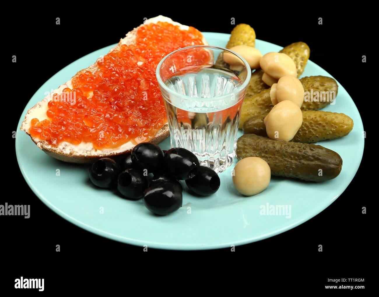 Composition with glass of vodka and snacks on color plate, isolated on ...