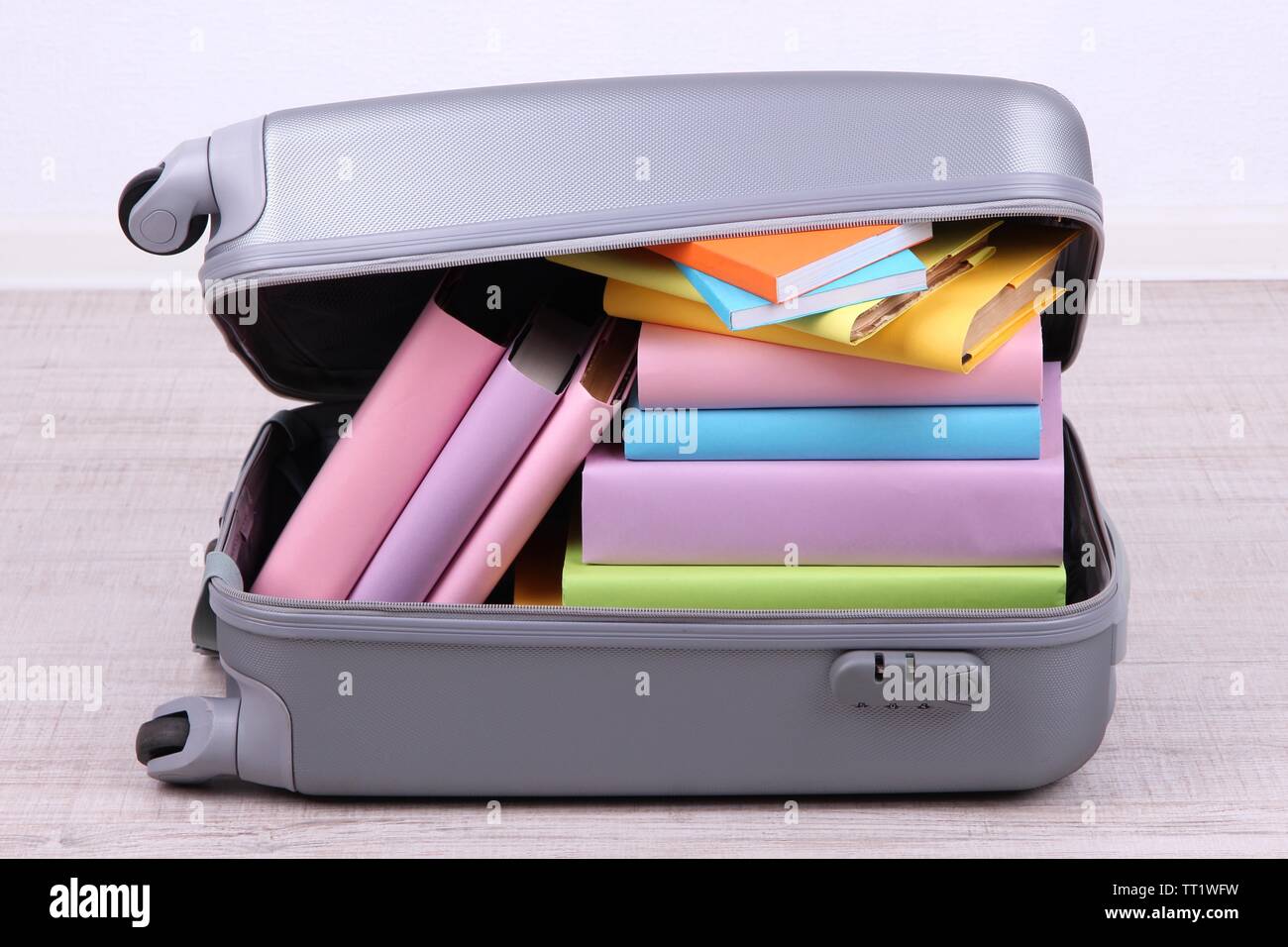 Books in suitcase on wall background Stock Photo - Alamy