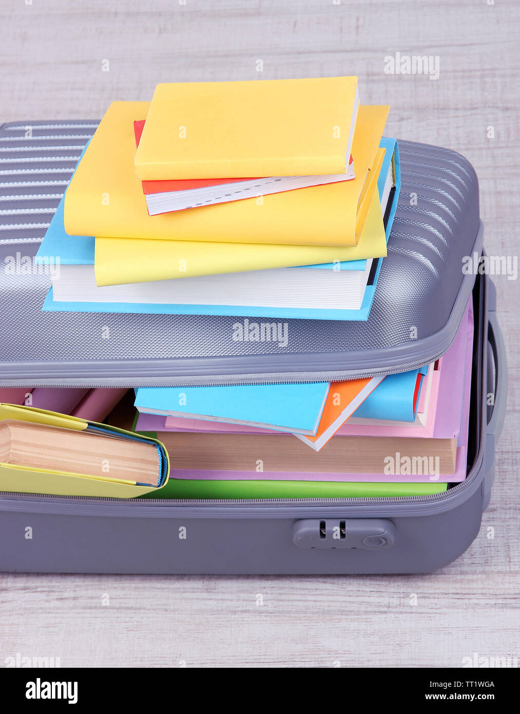 Books in suitcase on wall background Stock Photo - Alamy
