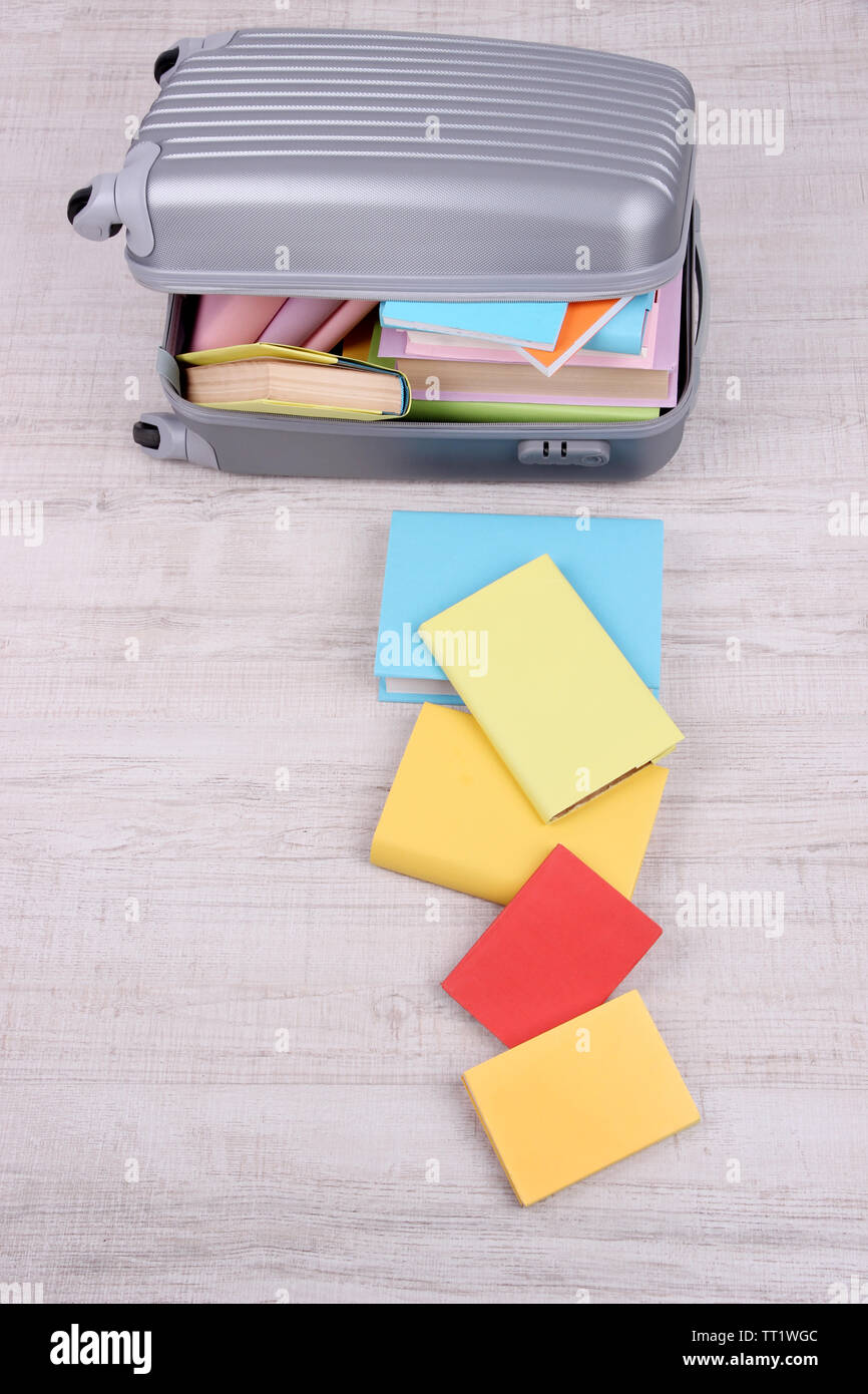 Books in suitcase on wall background close-up Stock Photo - Alamy