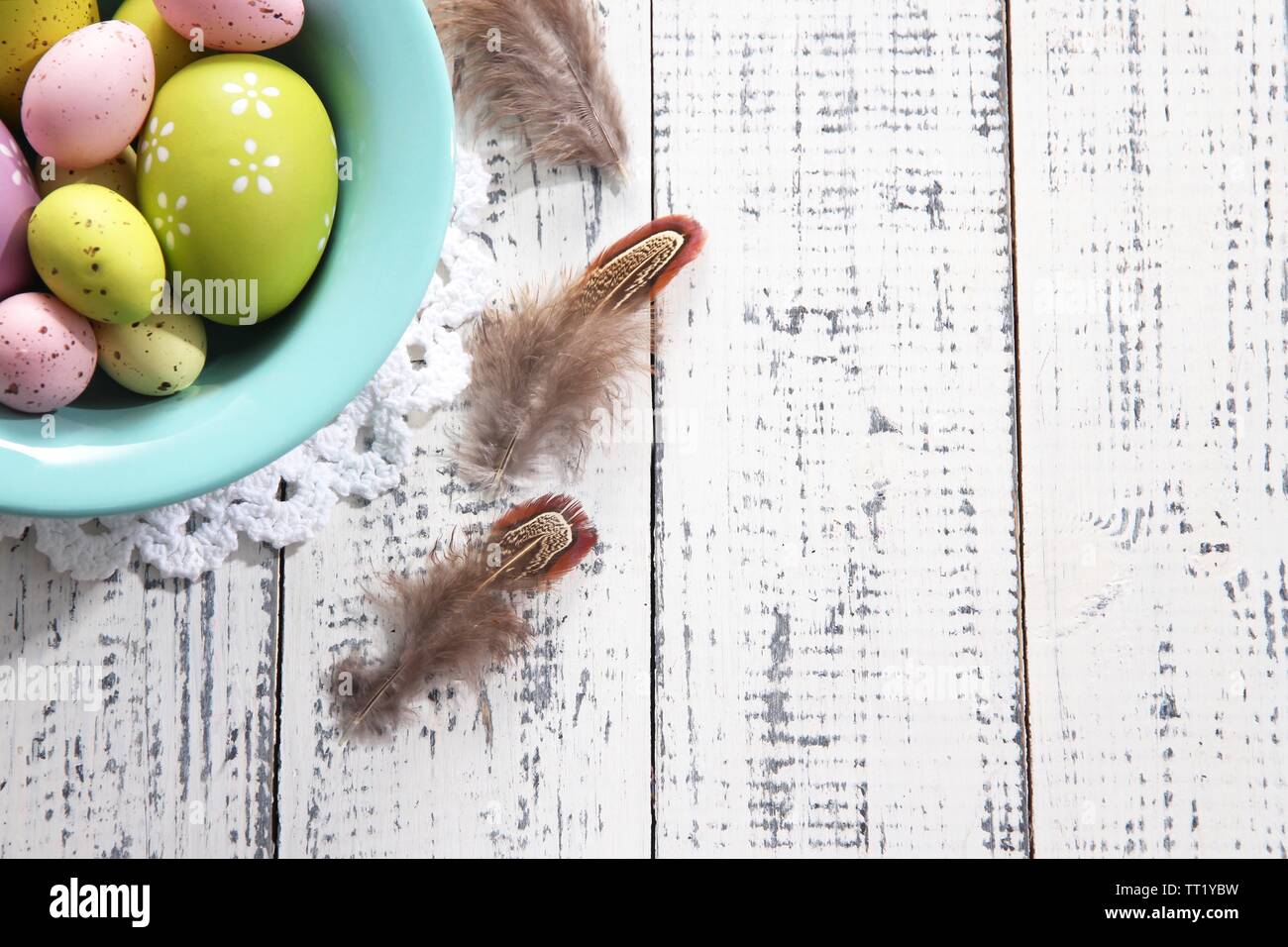 Easter eggs in color bowl on color wooden background Stock Photo - Alamy
