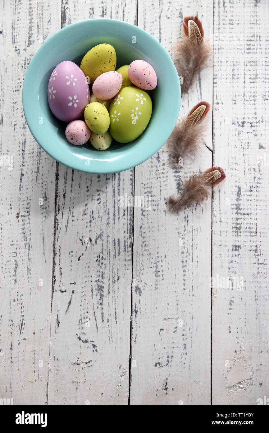 Easter eggs in color bowl on color wooden background Stock Photo - Alamy
