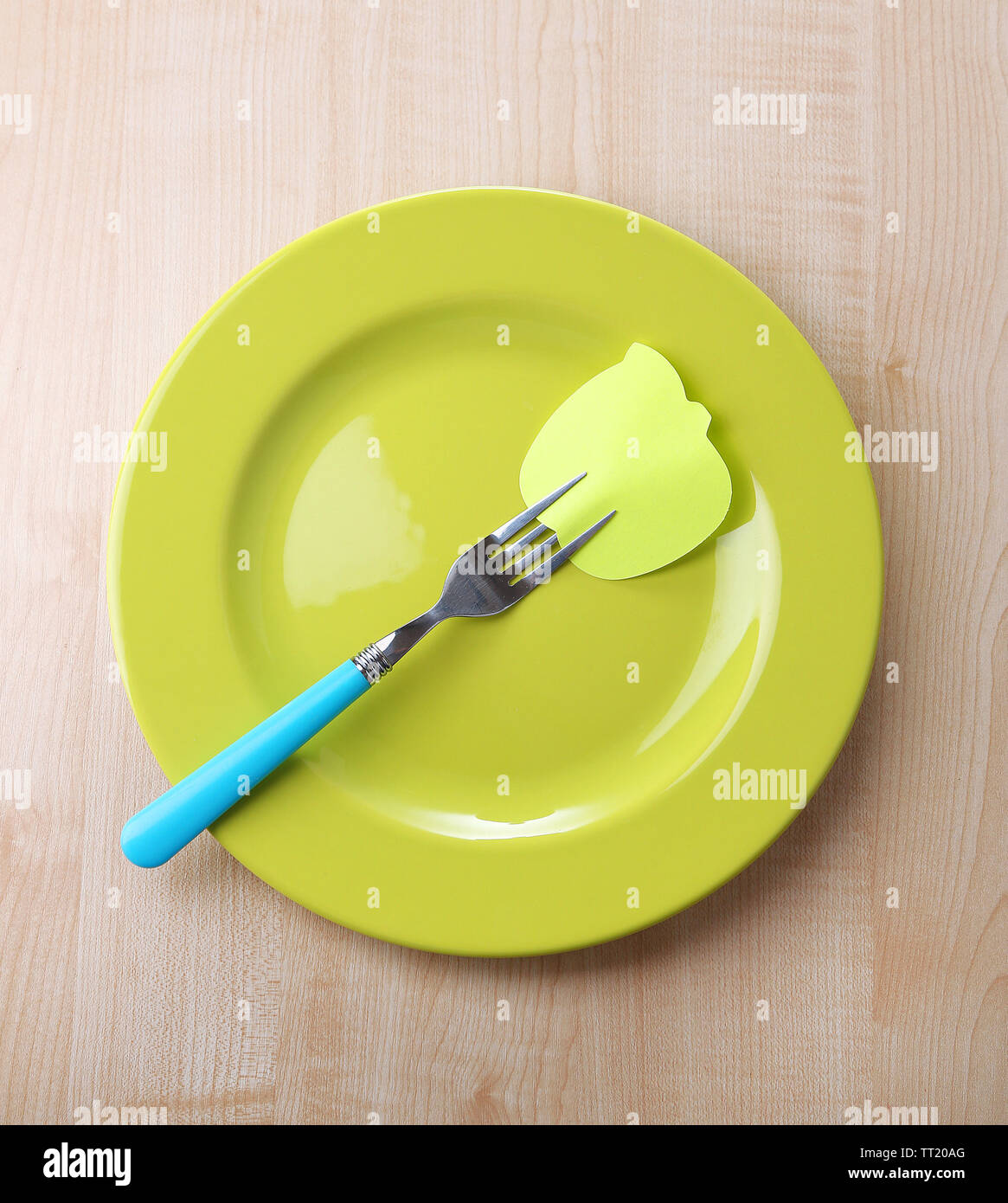 Empty note paper attached to fork, on plate, on color wooden background ...