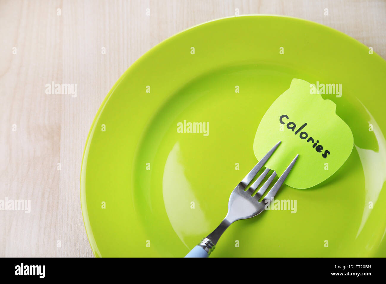 Note paper with message attached to fork, on plate, on wooden ...