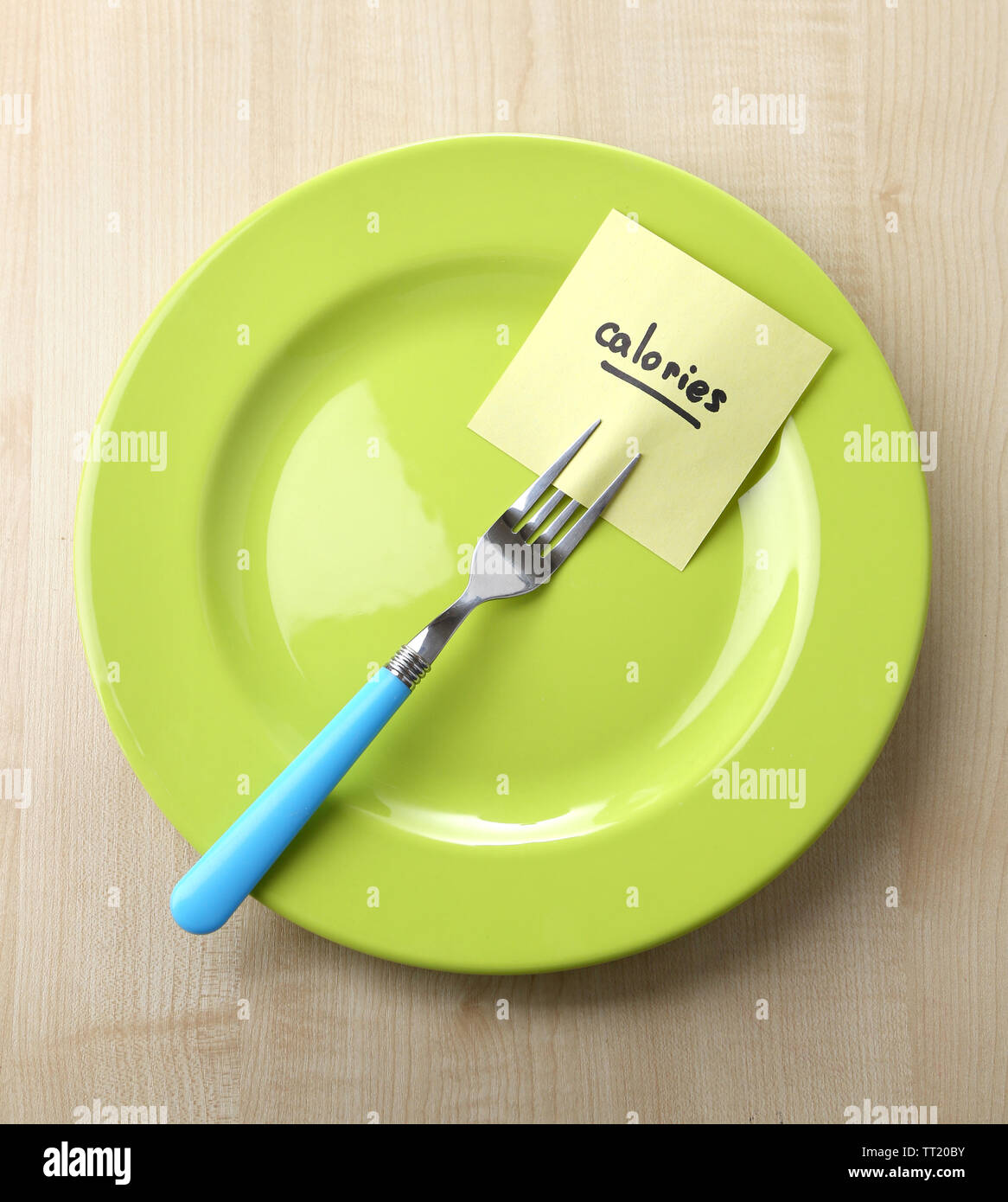 Note paper with message attached to fork, on plate, on wooden ...
