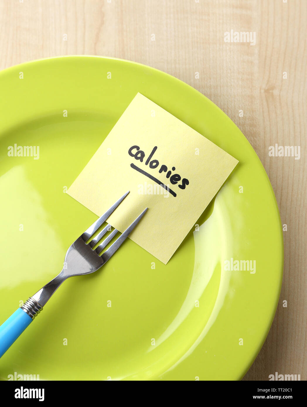 Note paper with message attached to fork, on plate, on wooden ...