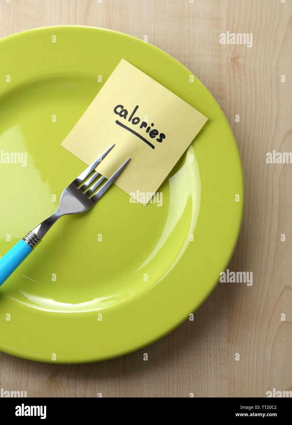Note paper with message attached to fork, on plate, on wooden ...