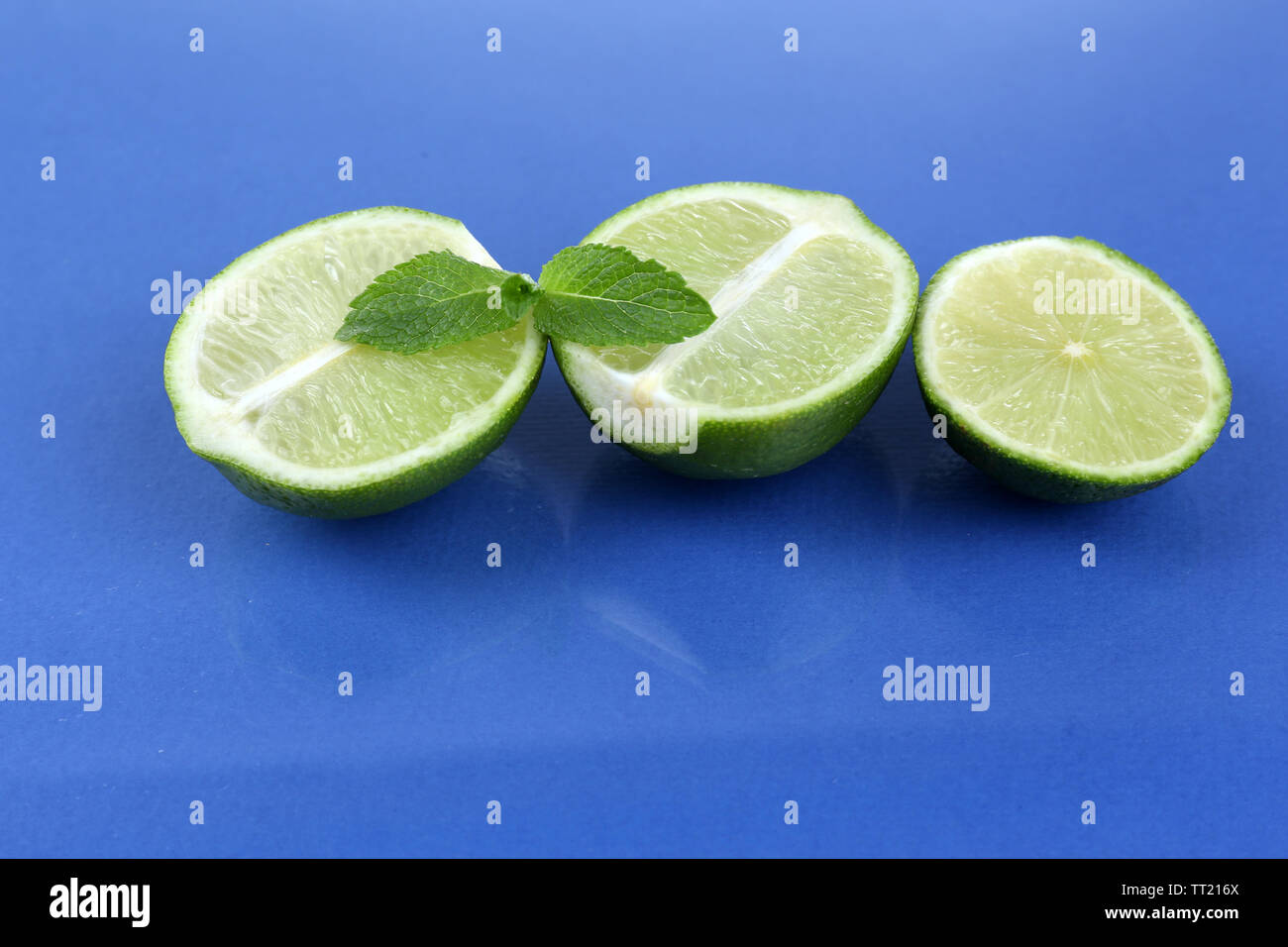 Fresh limes, on blue background Stock Photo - Alamy