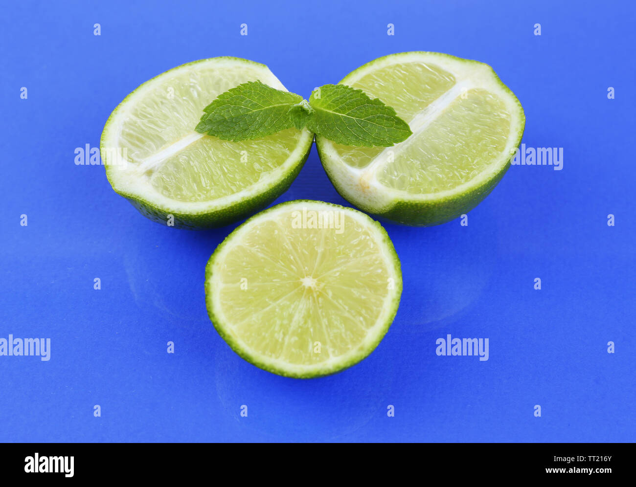 Fresh limes, on blue background Stock Photo - Alamy
