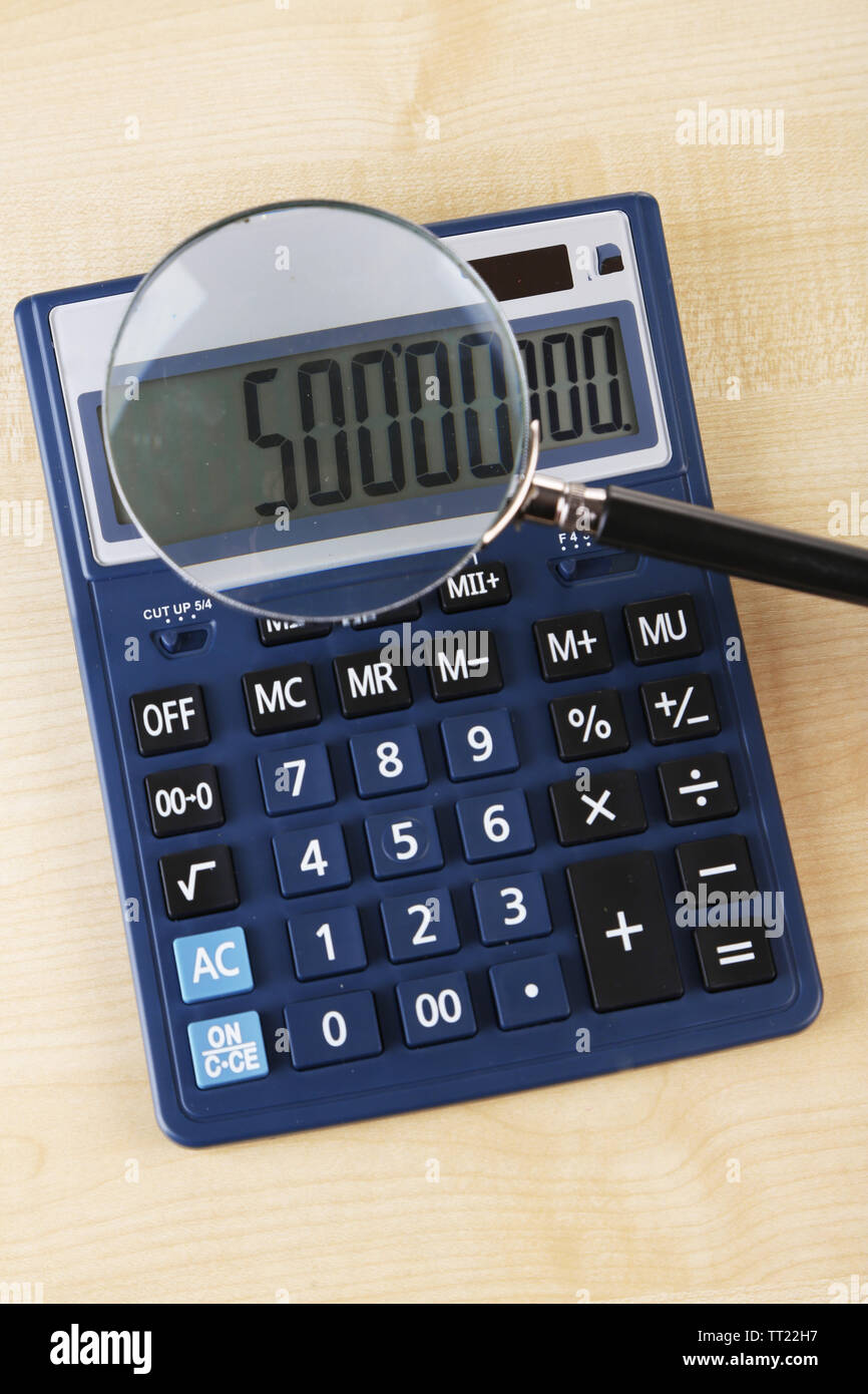 Fraud concept with magnifier and calculator, on wooden background Stock ...