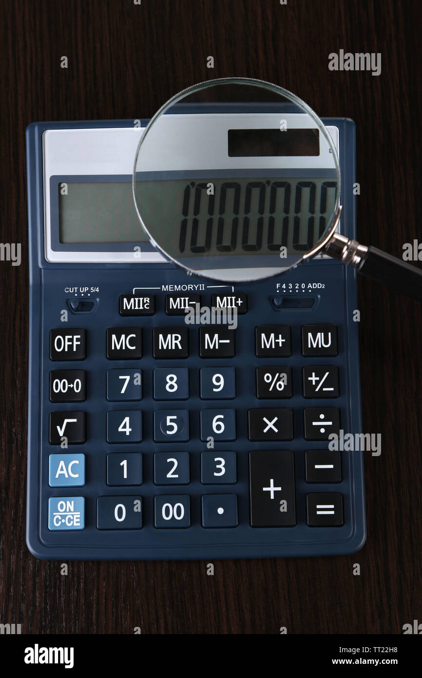 Fraud concept with magnifier and calculator, on wooden background Stock ...