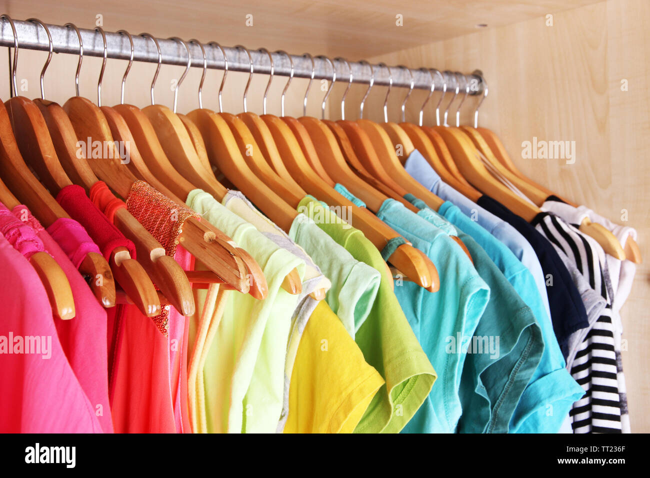 Colorful clothes hanging in wardrobe Stock Photo - Alamy