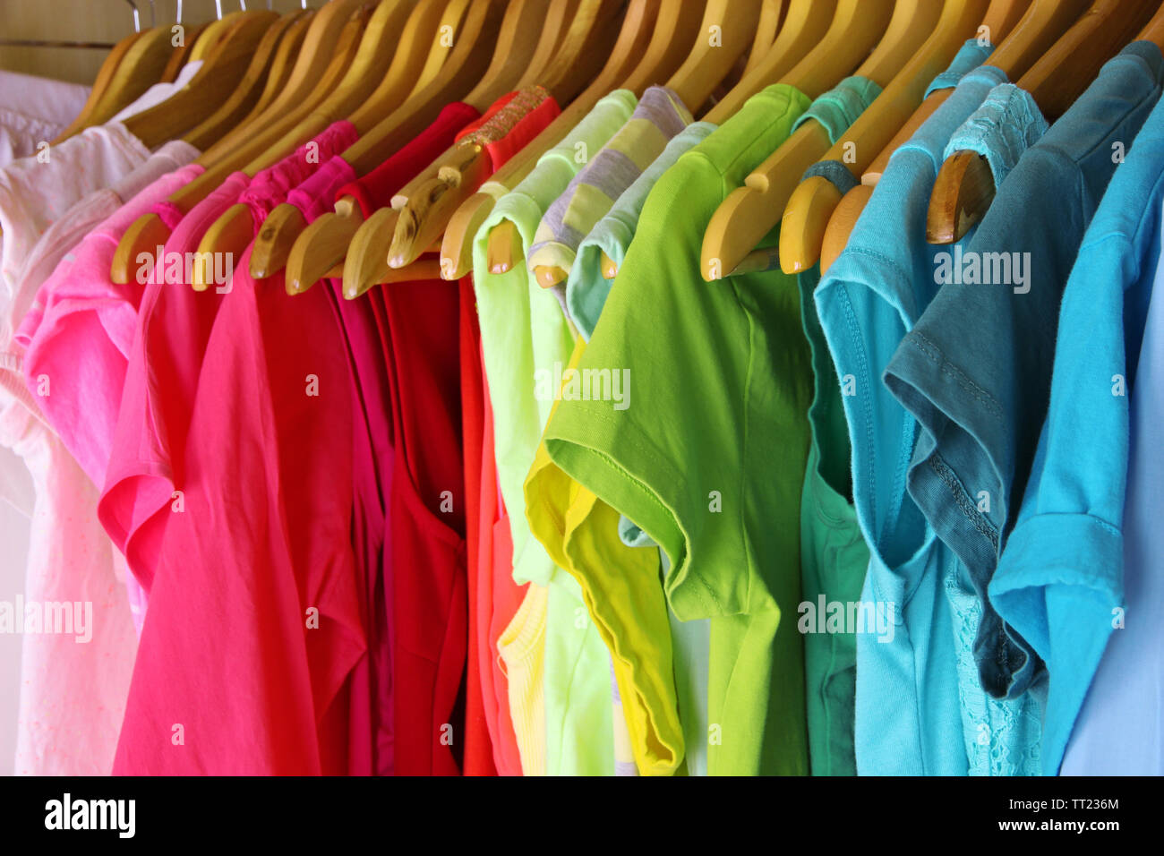 Colorful clothes hanging in wardrobe Stock Photo - Alamy