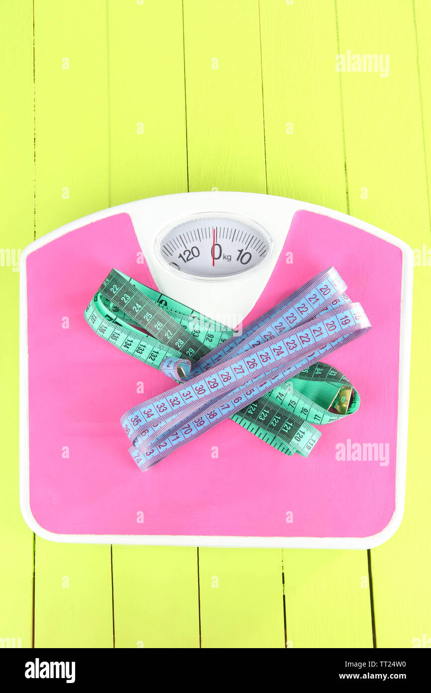 Measuring tape and scales close-up on wooden table Stock Photo - Alamy