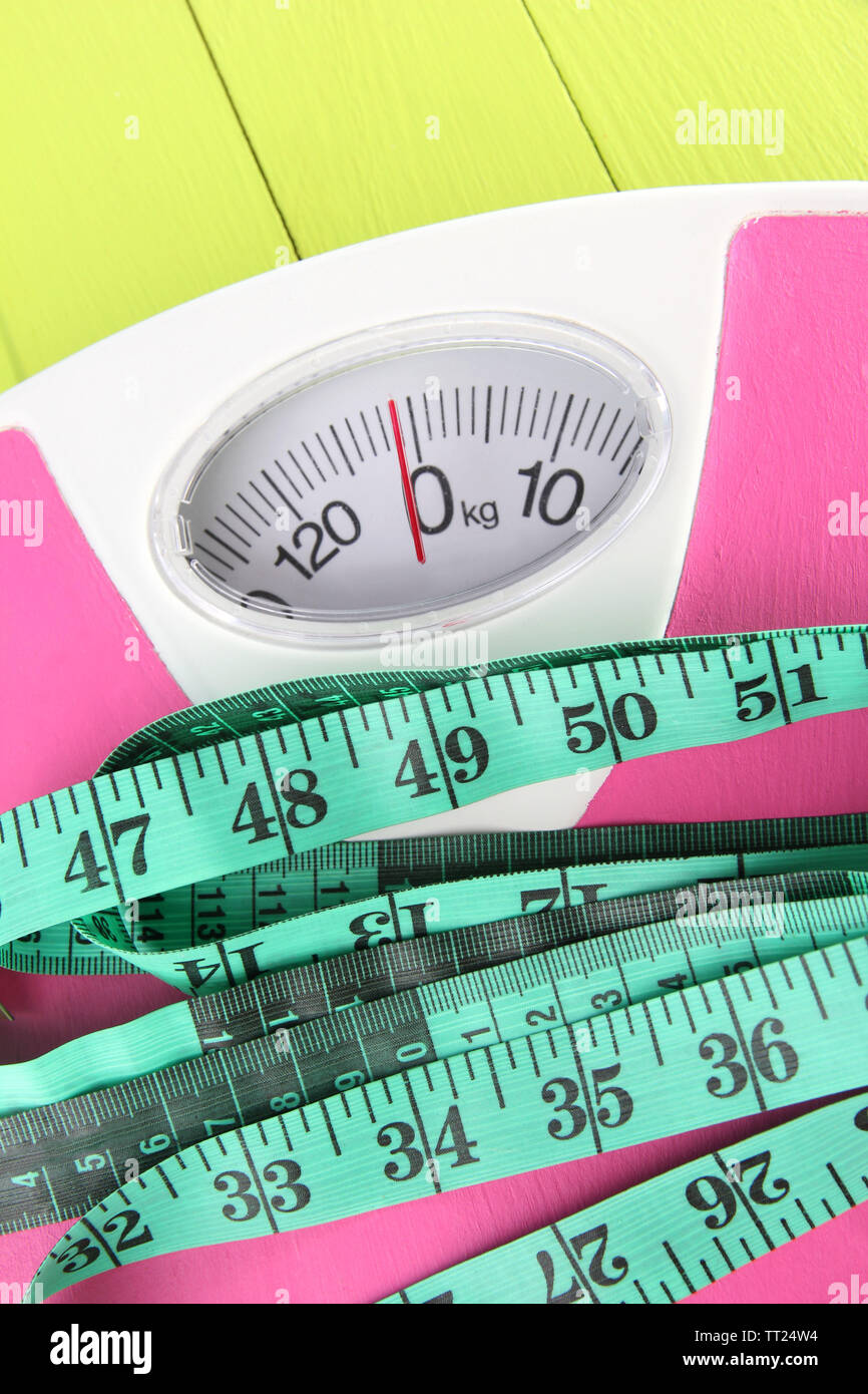 Measuring tape and scales close-up on wooden table Stock Photo - Alamy
