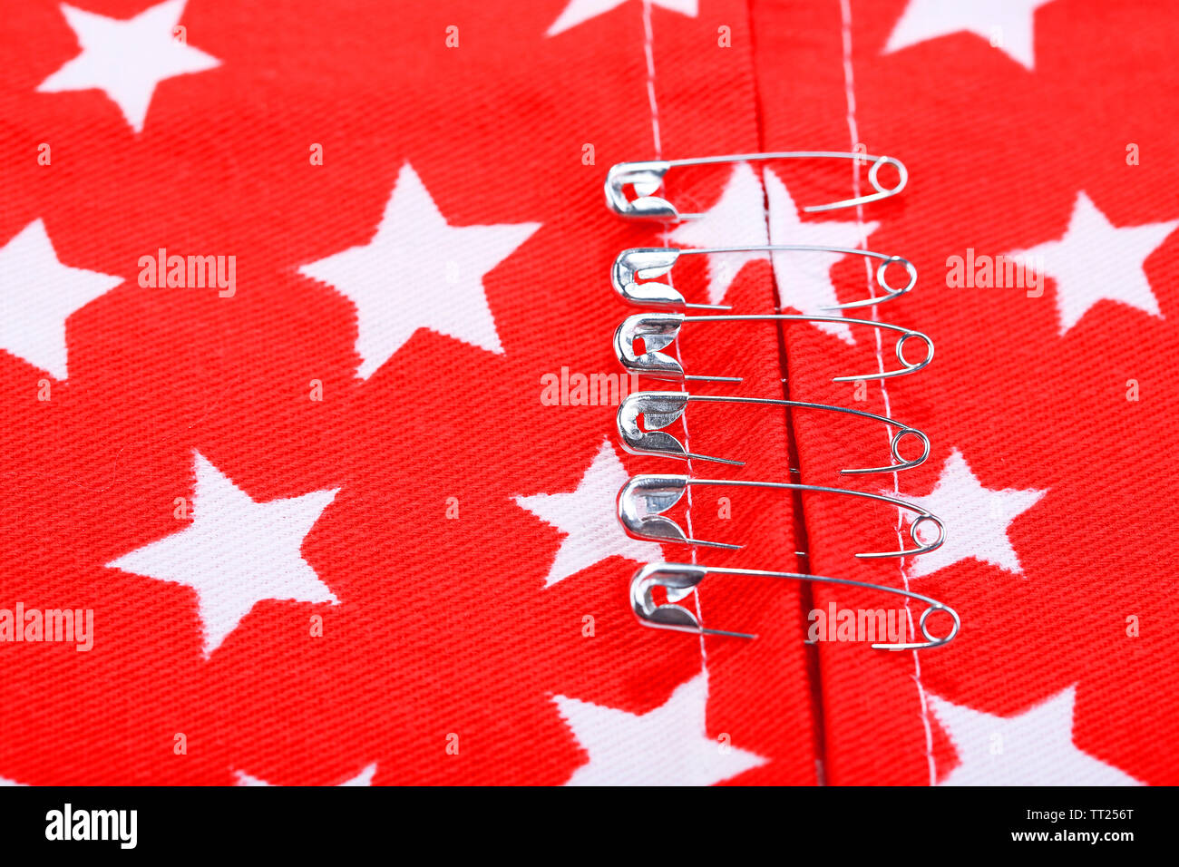 Safety pins on fabric background Stock Photo - Alamy