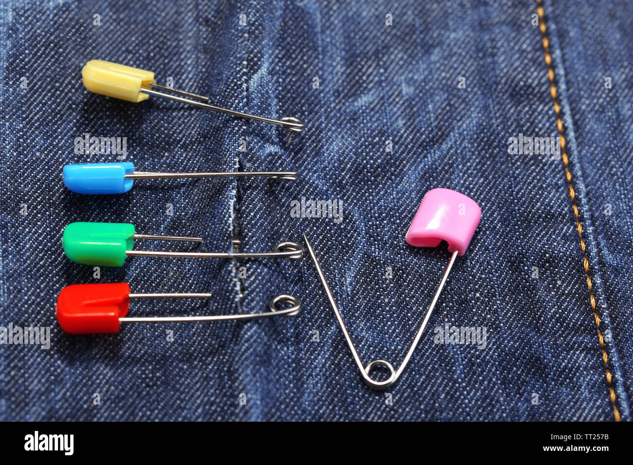 Safety pins on fabric background Stock Photo - Alamy