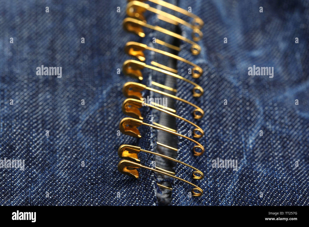 Safety pins on fabric background Stock Photo - Alamy