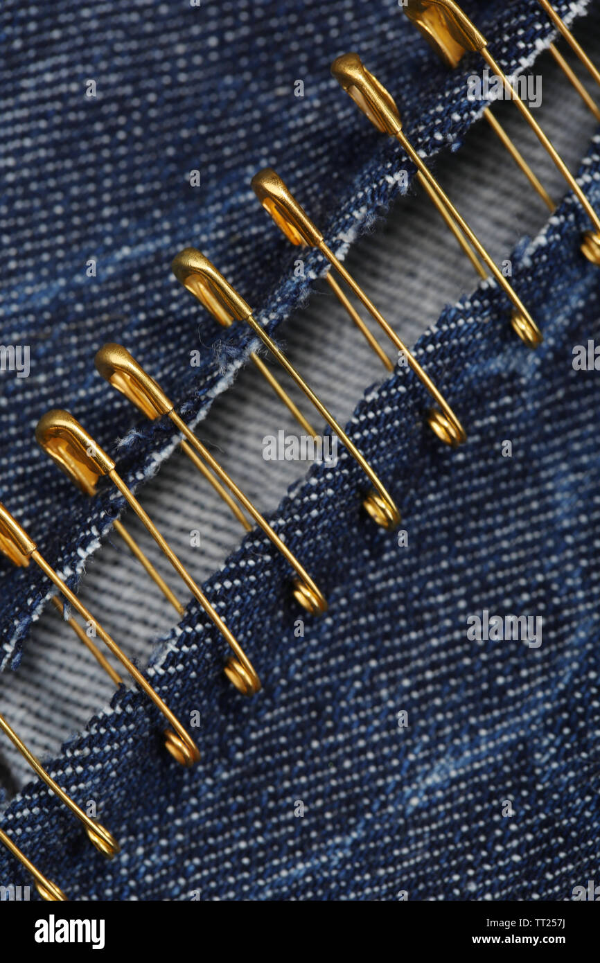 Safety pins on fabric background Stock Photo - Alamy
