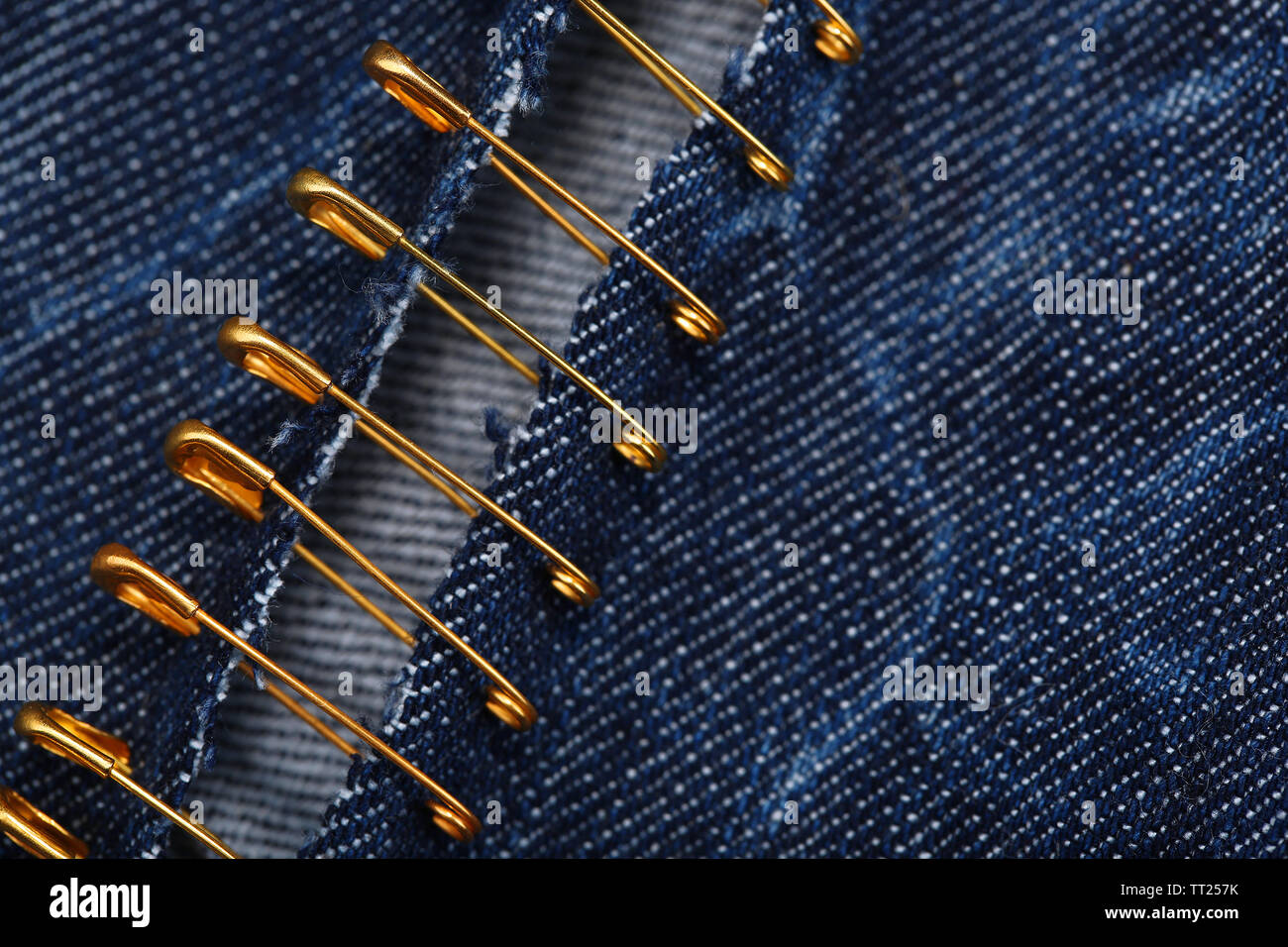 Safety pins on fabric background Stock Photo - Alamy