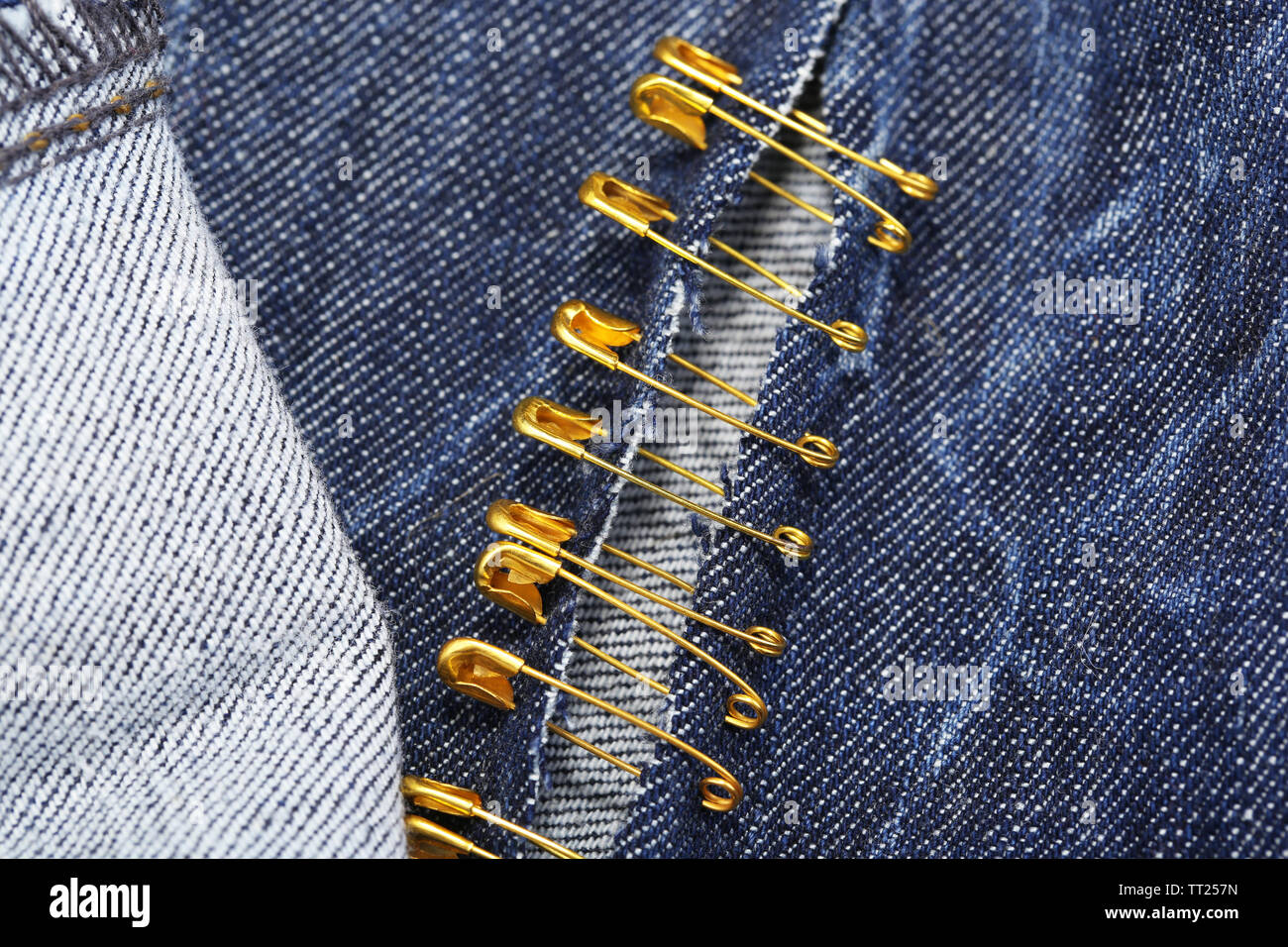 Safety pins on fabric background Stock Photo - Alamy