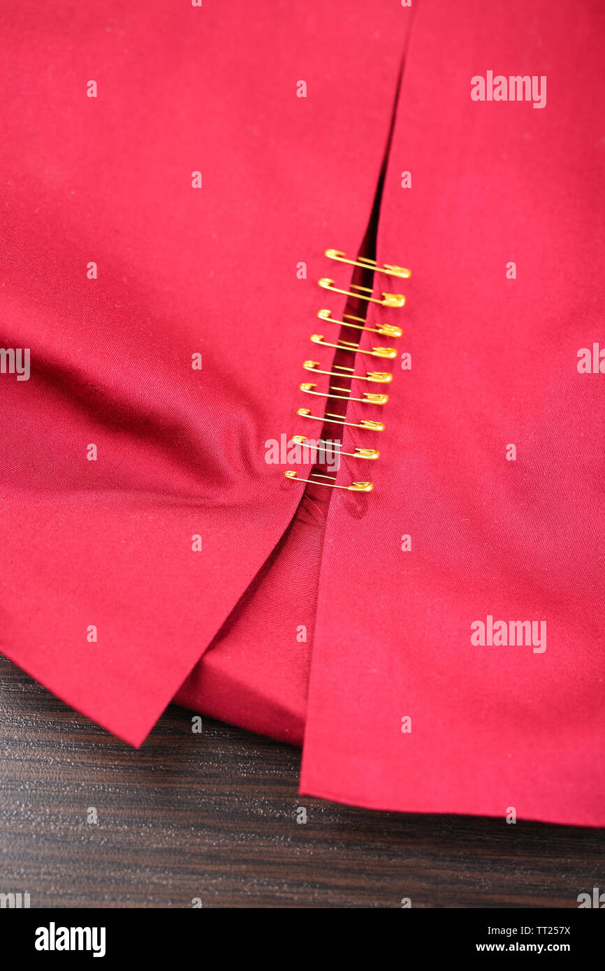 Safety pins on fabric background Stock Photo - Alamy