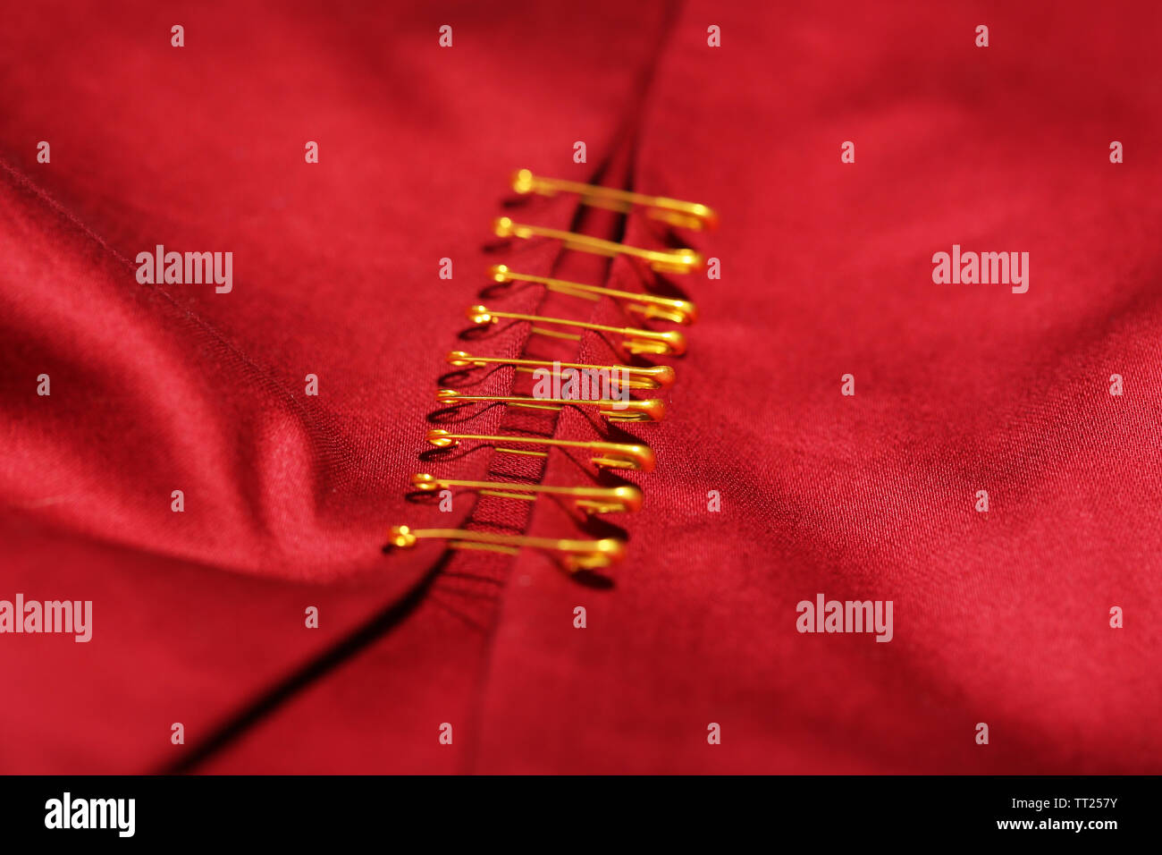 Safety pins on fabric background Stock Photo - Alamy