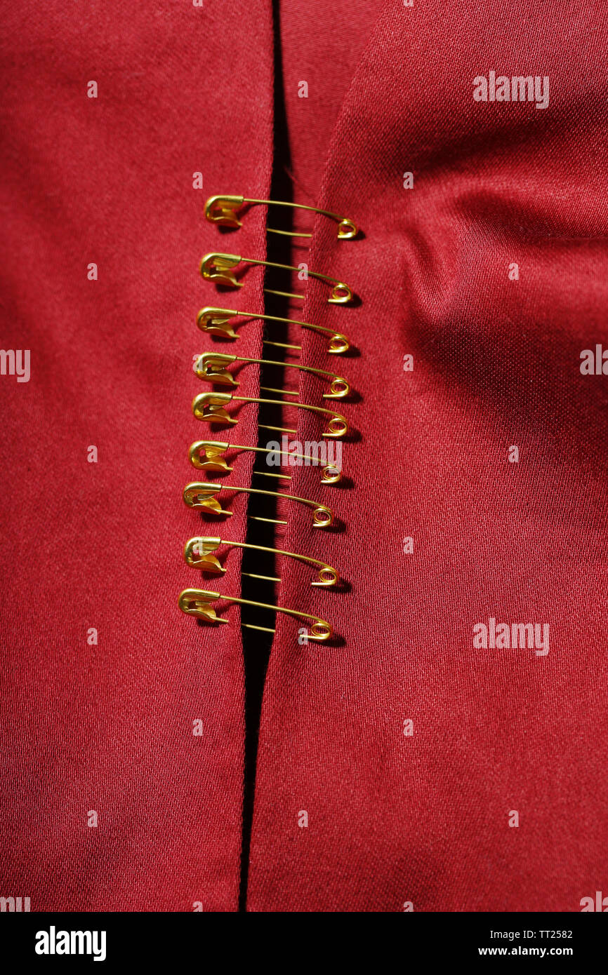Safety pins on fabric background Stock Photo - Alamy