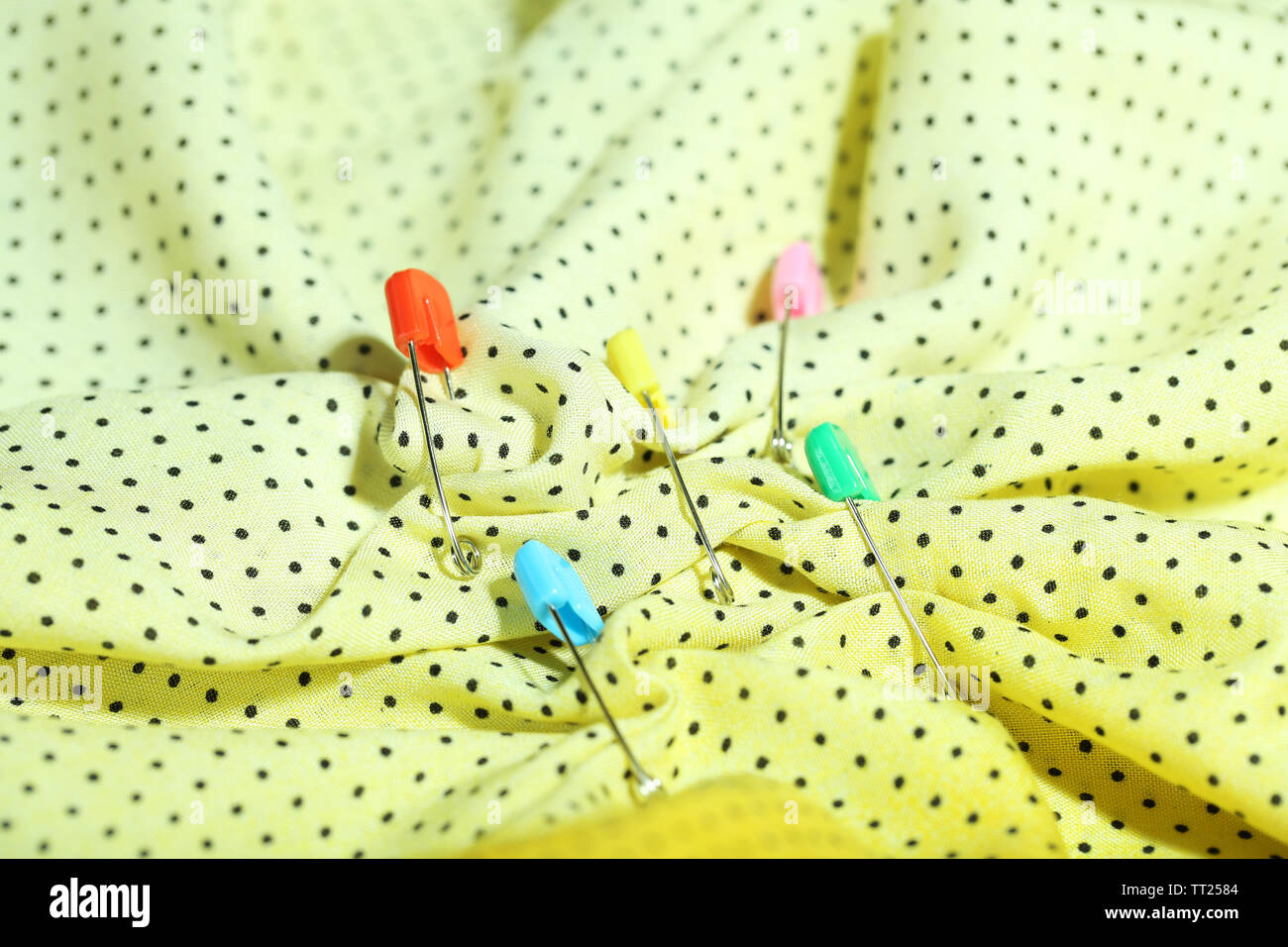 Safety pins on fabric background Stock Photo - Alamy